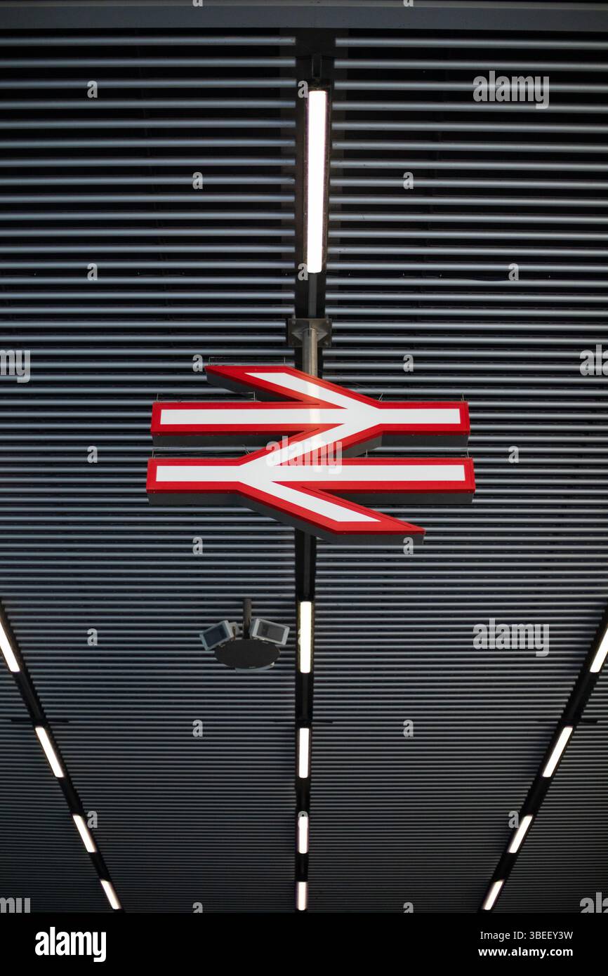 A British Rail logo sign hangs from a station ceiling in London. The ...