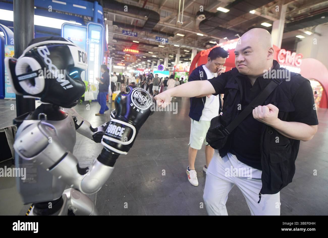 A visitor interacts with a boxing humanoid developed based on Unitree's ...