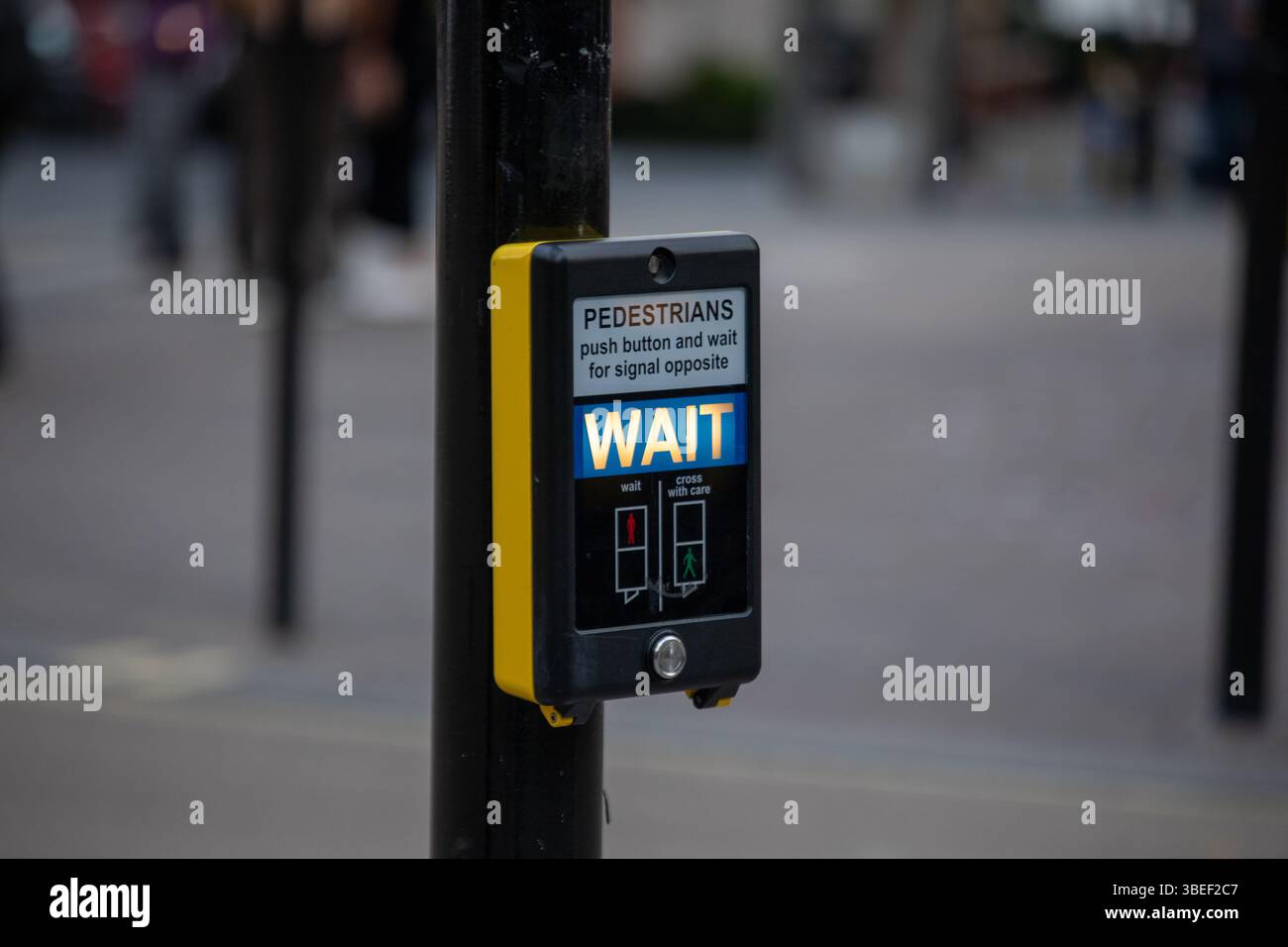 Close-up of a pedestrian traffic signal button displaying WAIT on a ...