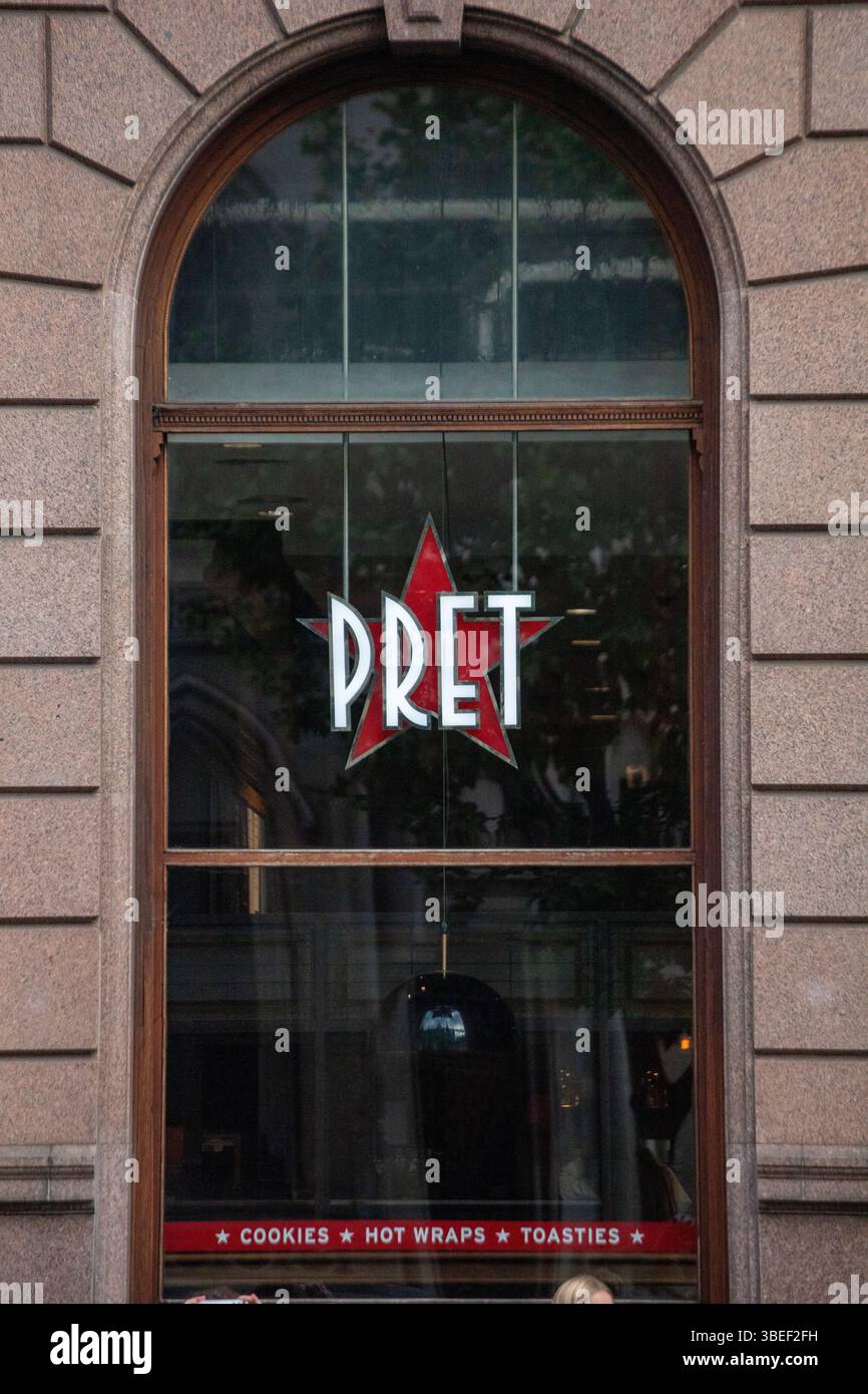A Pret storefront window in London displays branded signage with a star ...