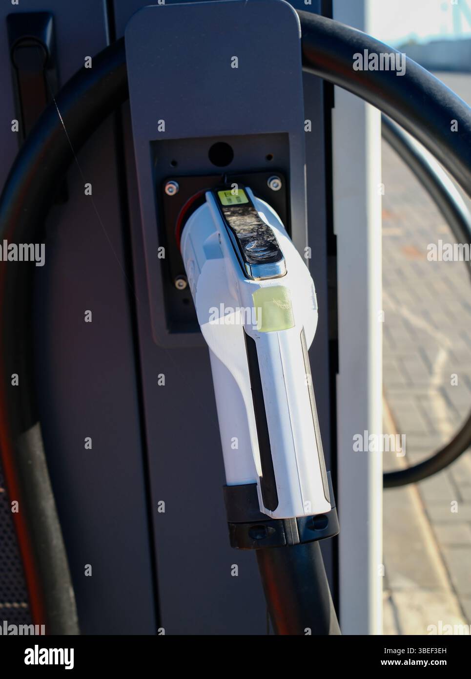 Close-up of white electric car charging connector plugged into EV ...