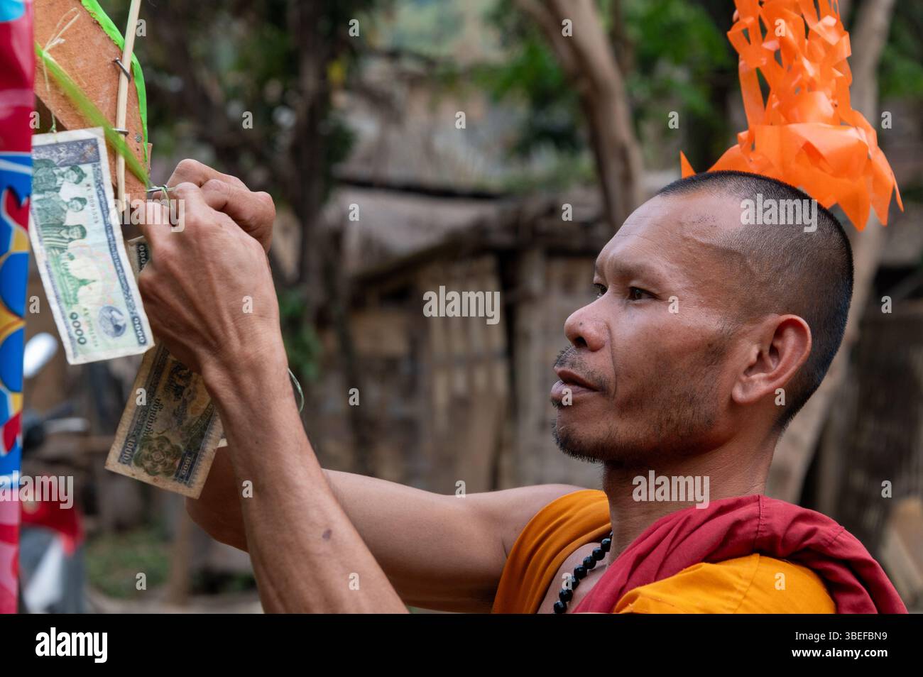 A Buddhist monk helps hang Laotian bank notes to a wash line at the ...