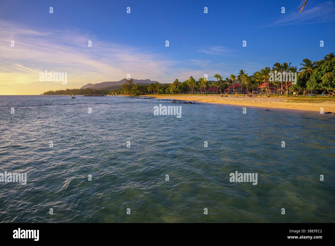Bel Ombre beach in southern Mauritius with palm trees and sunset light ...