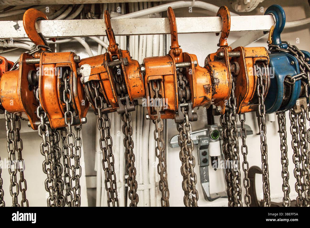 Chain hoists for lifting weights in a workshop close-up Stock Photo - Alamy