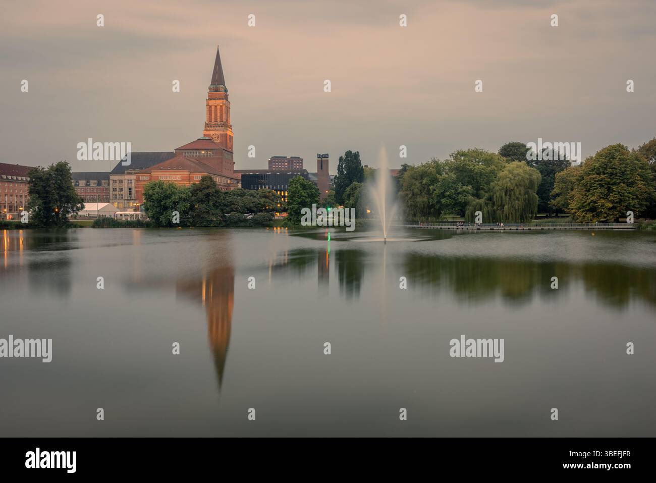 Long-exposure image of Kiel Town Hall and lake fountain at dusk, with ...