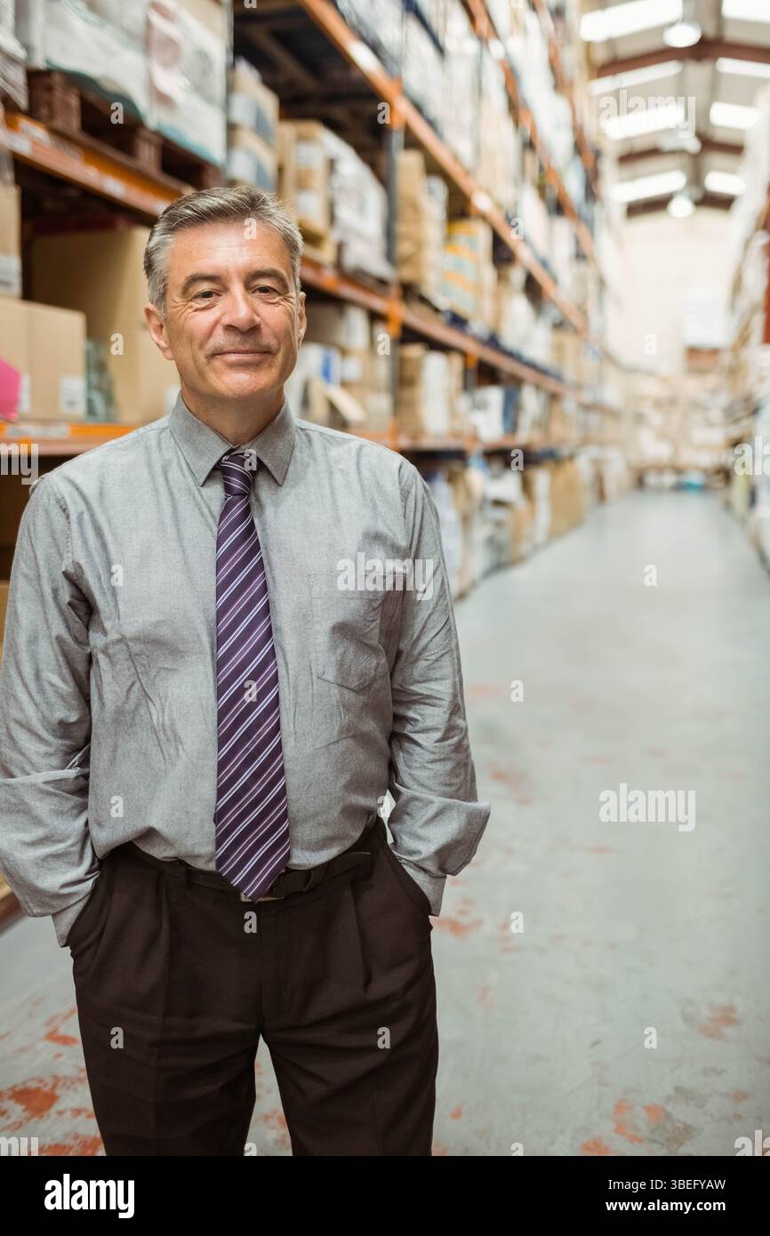 Standing male manager wearing gray shirt and purple tie in warehouse ...