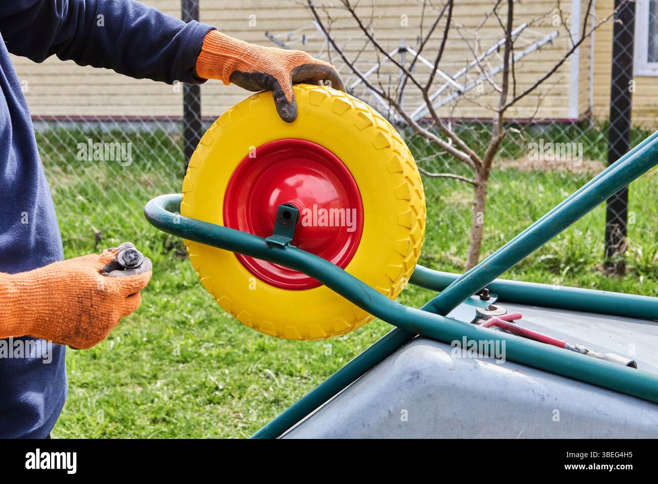 Gardener farmer changing fixing wheelbarrow hi-res stock photography ...