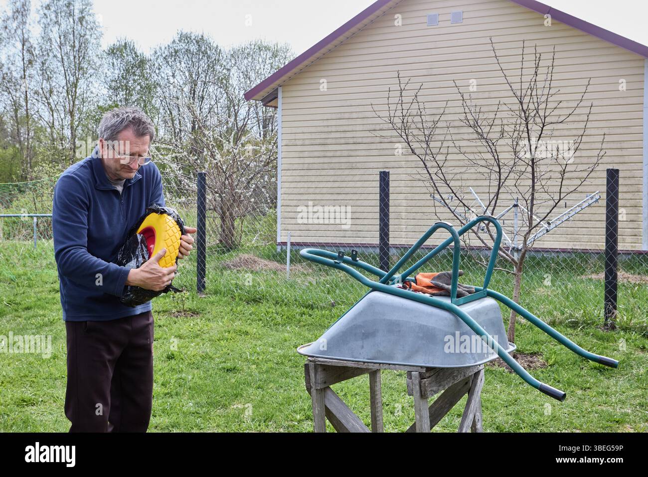 Farmer fixing new wheelbarrow wheel hi-res stock photography and images ...