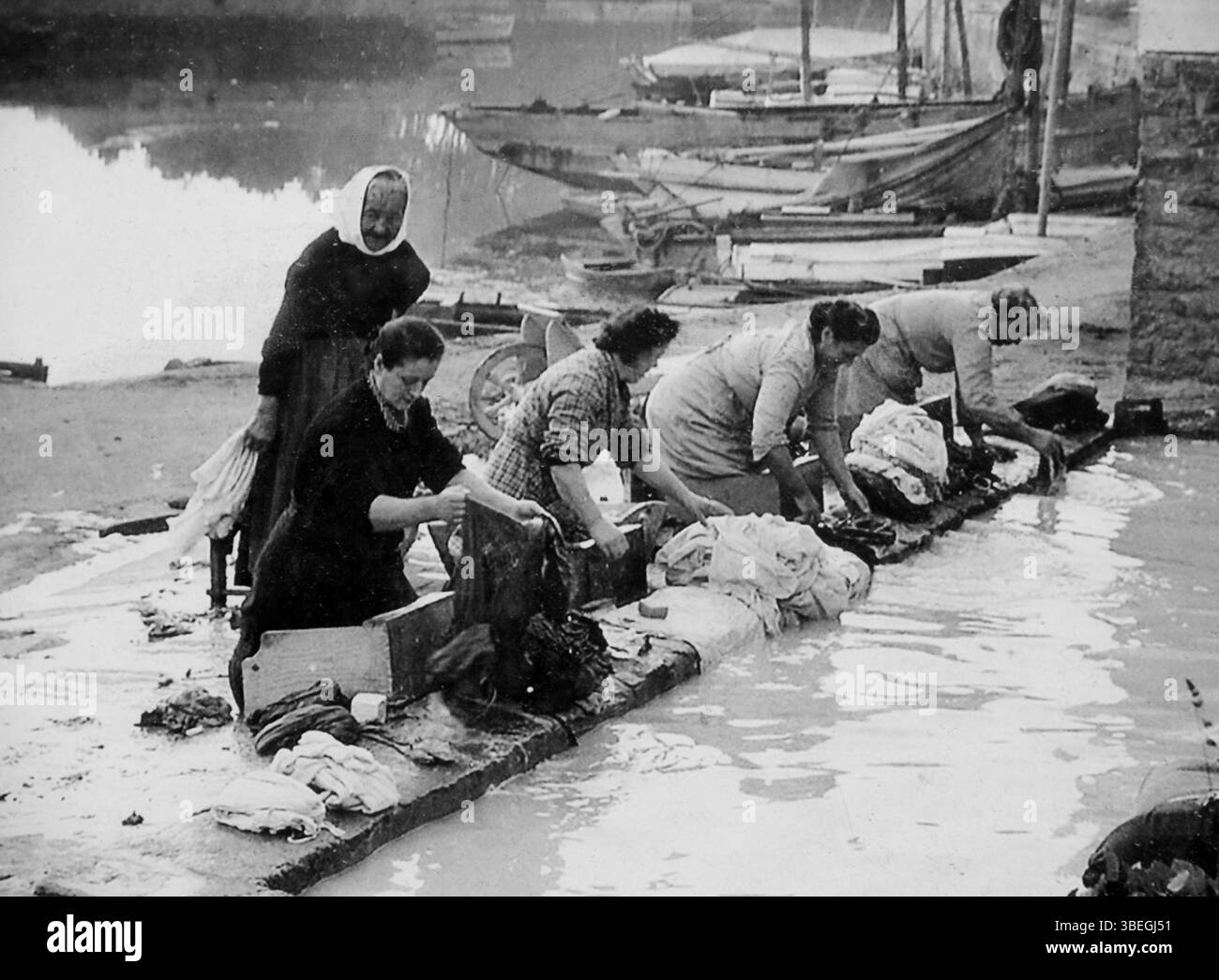 The image depicts women washing clothes (lavandières) at the port of ...