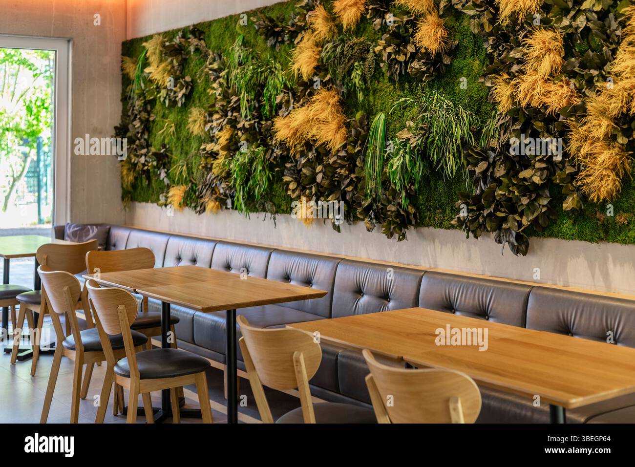 Cozy cafe features a stylish interior with wooden tables and chairs ...