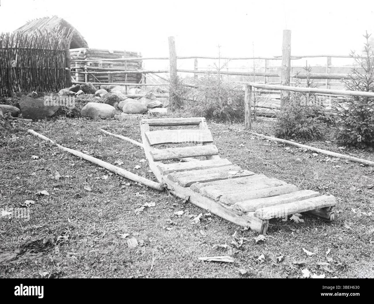 This image features a traditional wooden sled with iron-bound runners ...