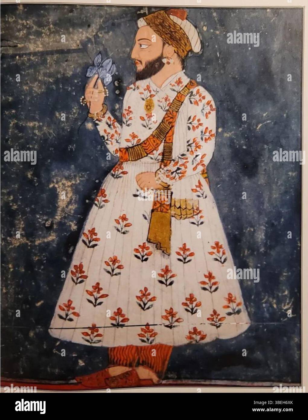 A Pahari-style painting of Guru Har Rai holding a flower, painted by a ...