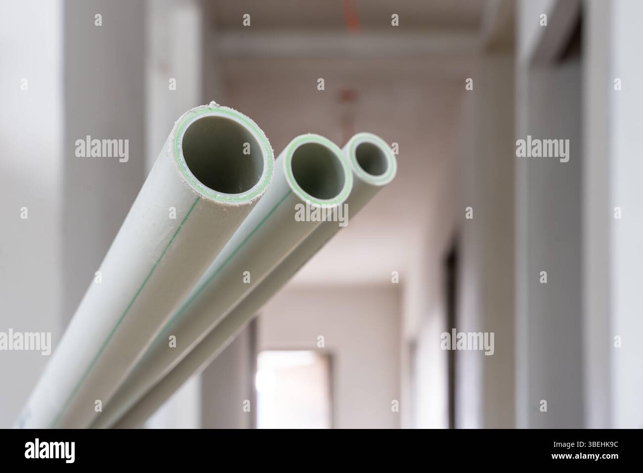 Three PVC pipes extending in an unfinished interior Stock Photo - Alamy