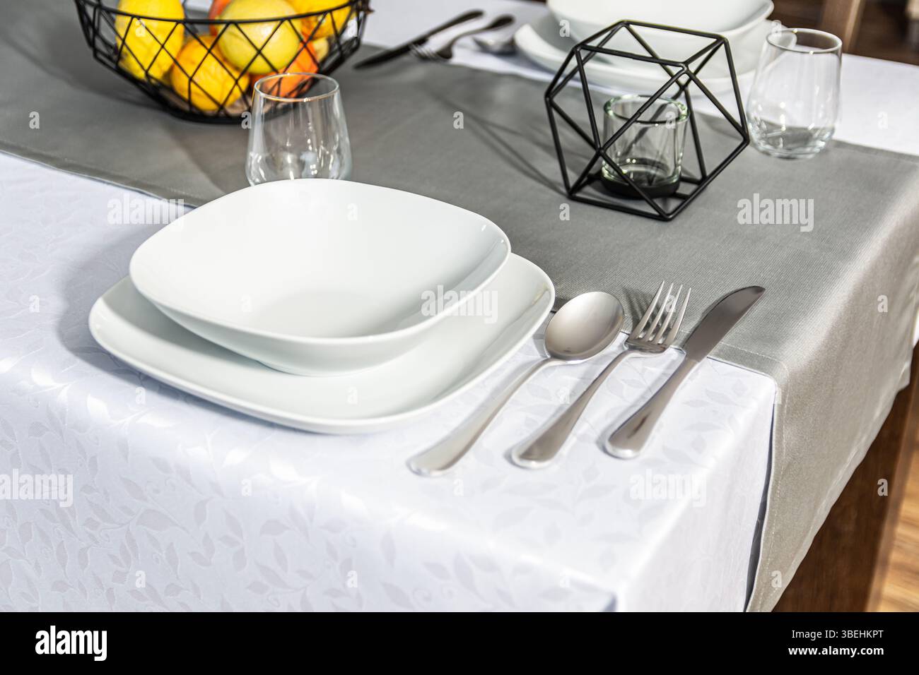 Elegant dining table with white and gray table setting Stock Photo - Alamy
