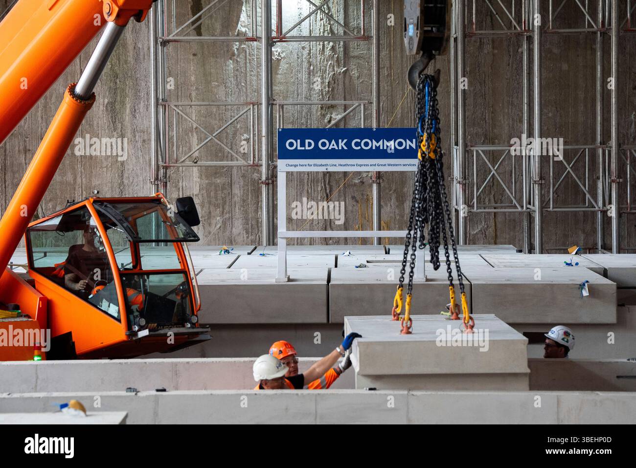 Construction workers lower a precast platform slab during the ...