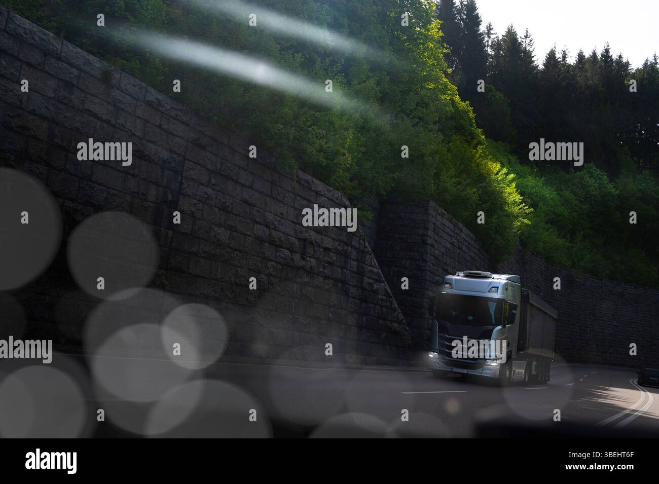 Heavy lorry truck with trailer drives slowly up the steep mountain road ...