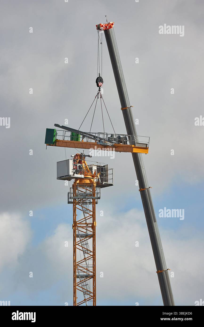 Tall Construction Cranes being assembled Stock Photo - Alamy