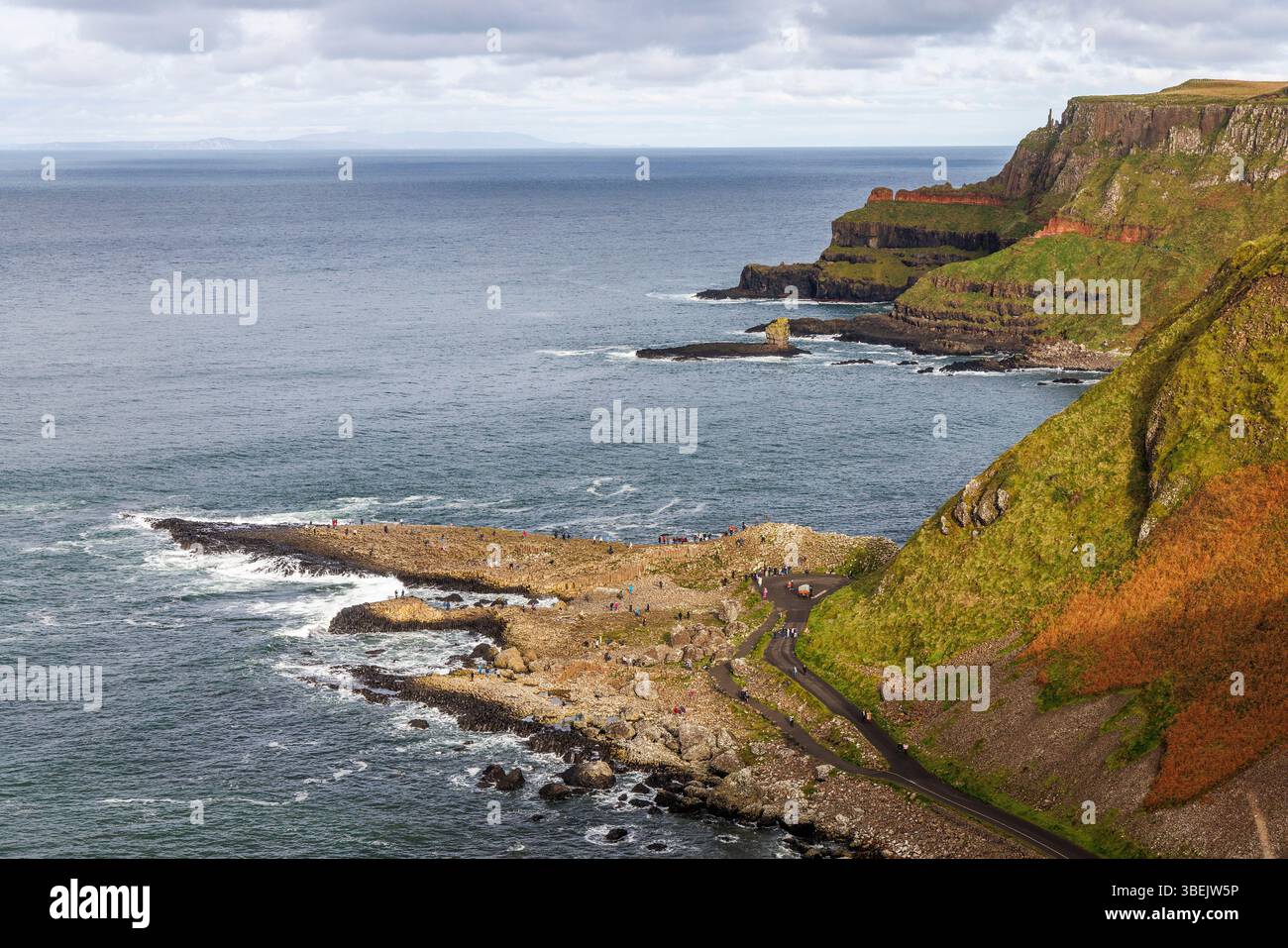 Giant's Causeway and coast path looking east with the Chimney Stacks in the distance, Co. Antrim ...