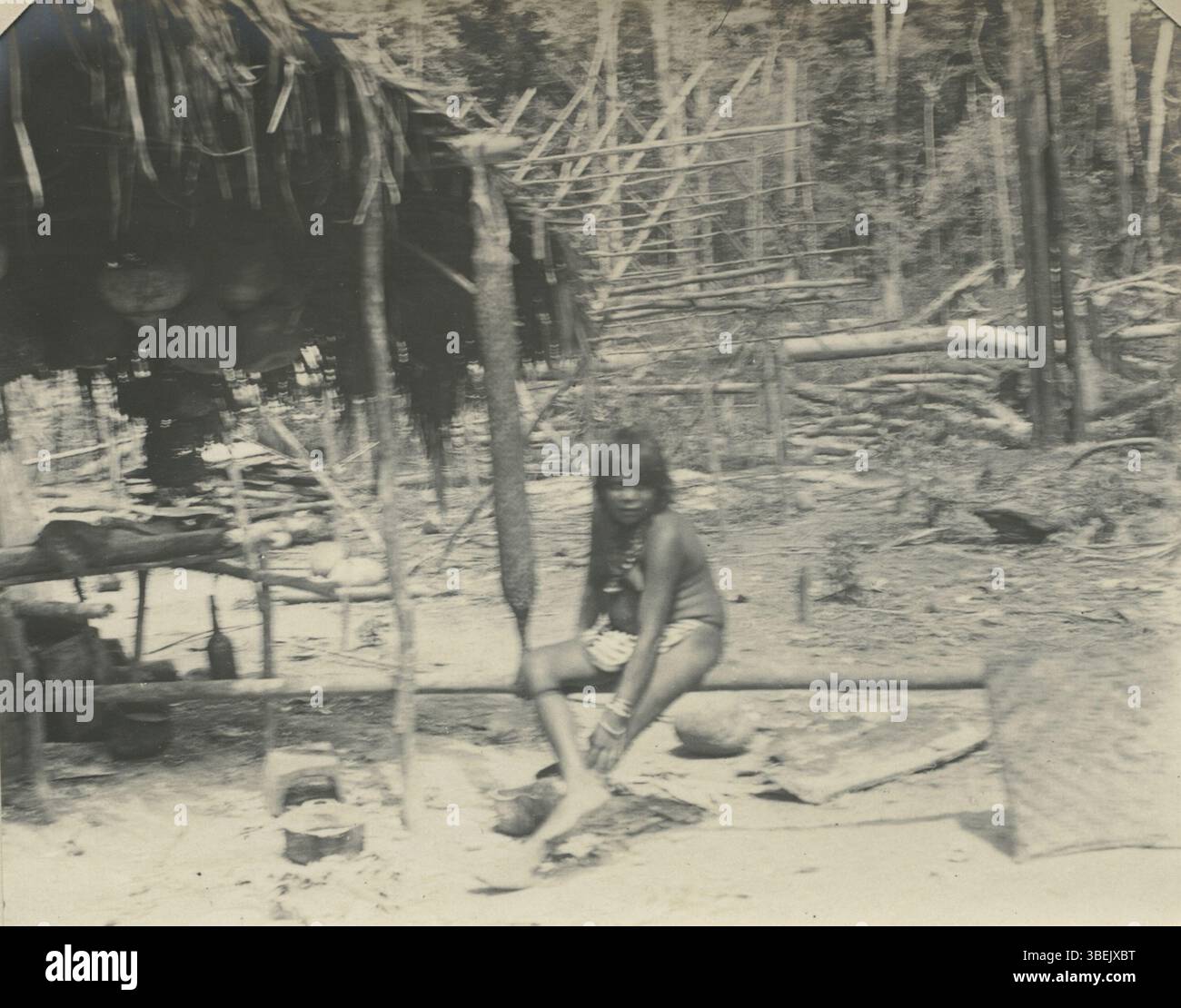 This early 20th-century image shows an indigenous woman pressing ...