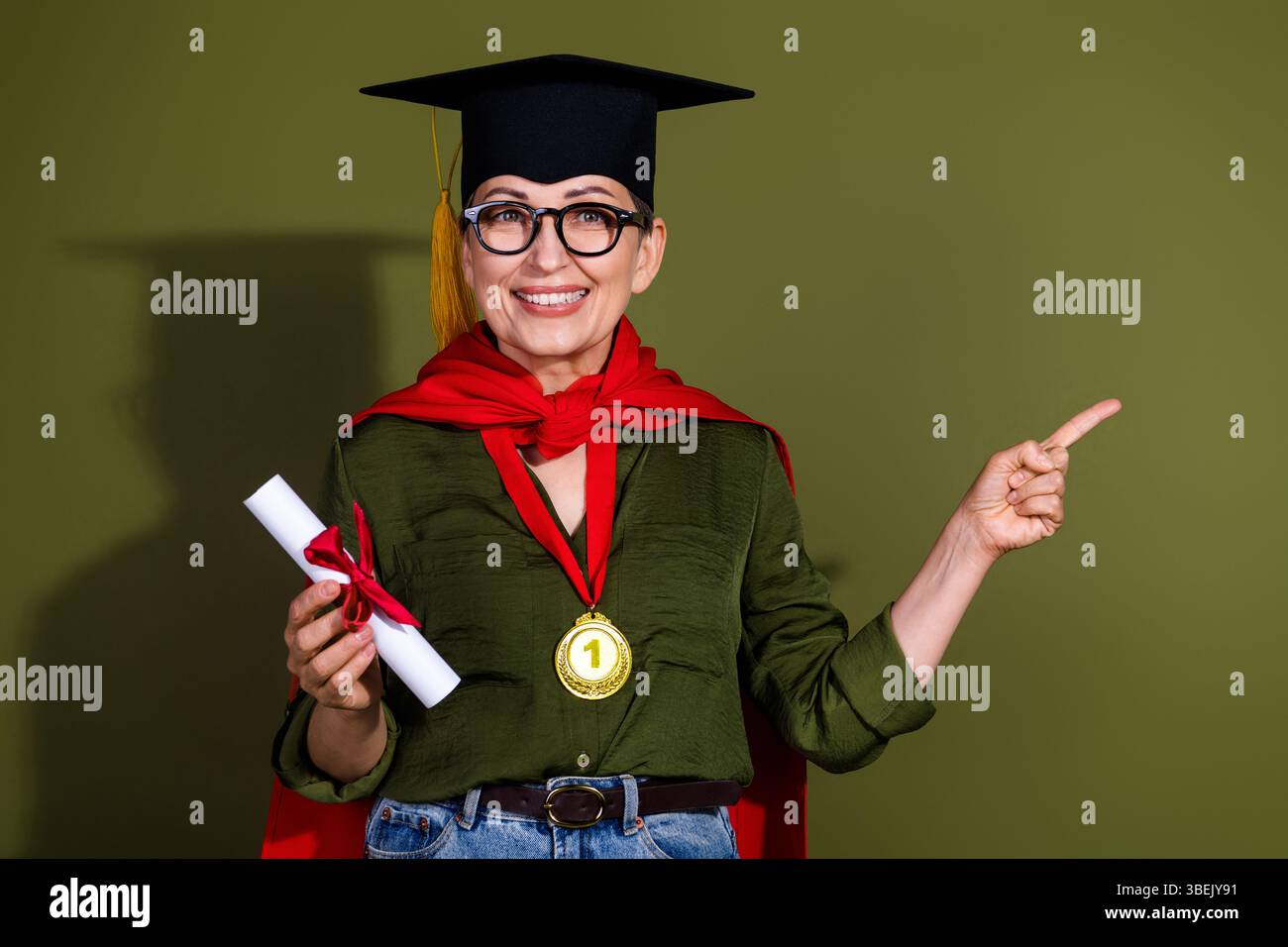Charming mature woman in graduation cap and cloak holding certificate ...