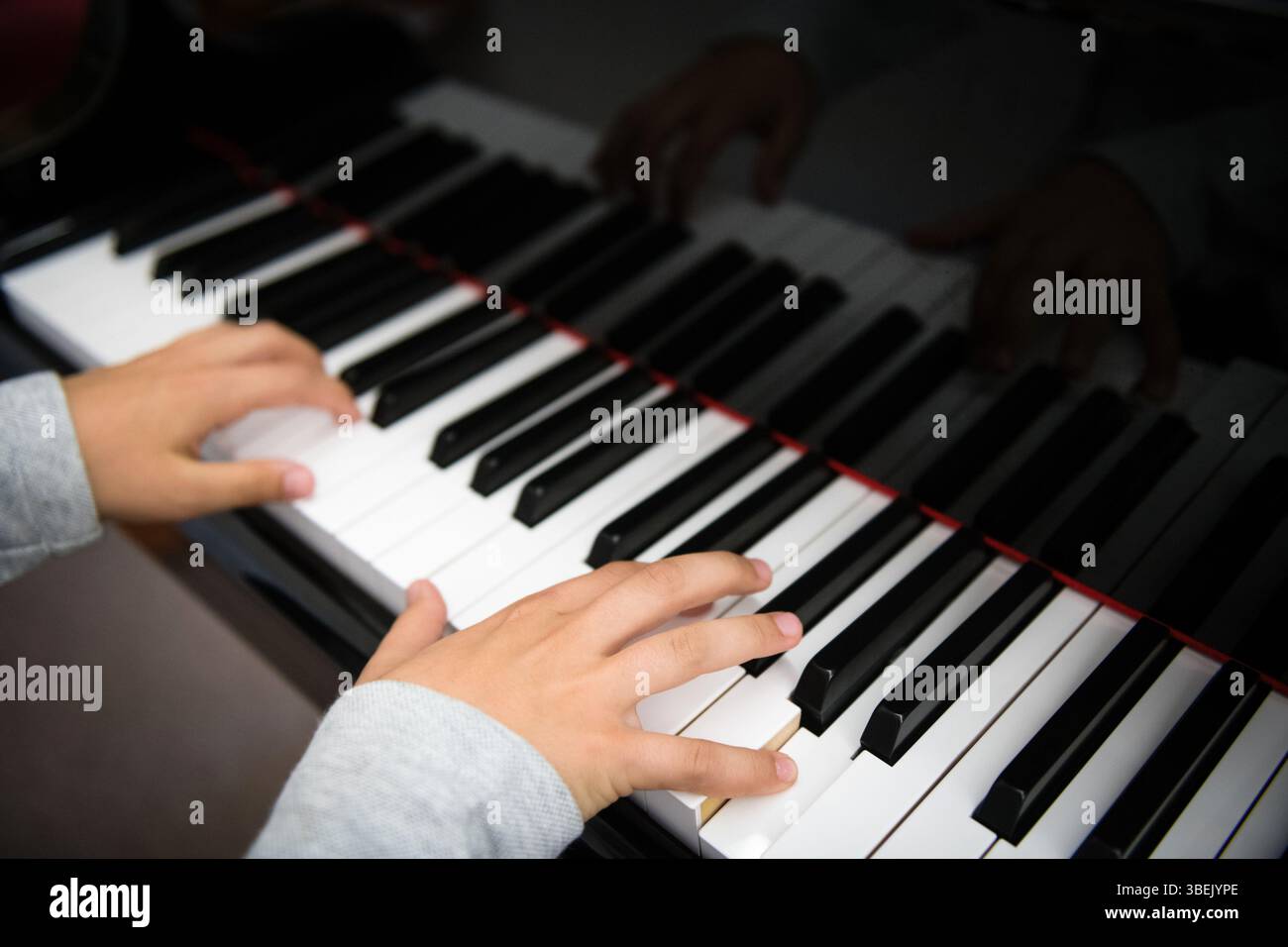 Kid playing on grand piano keyboard, shallow depth of field Stock Photo ...