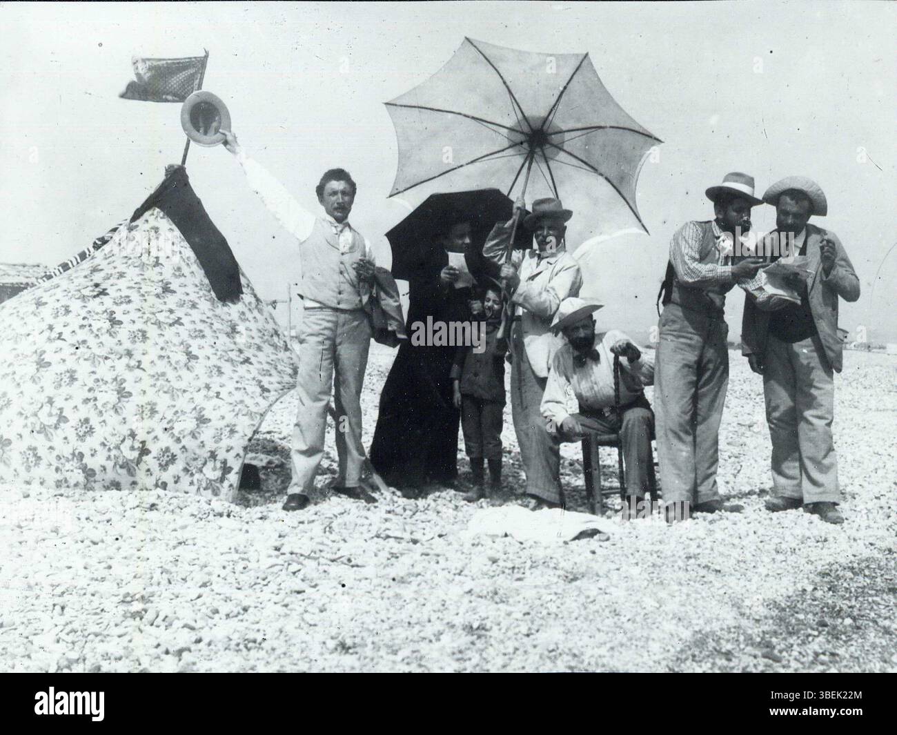 A nostalgic photograph from circa 1910, depicting beachgoers on the ...