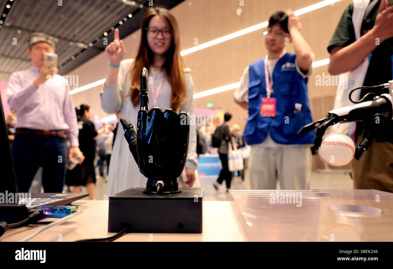 Shanghai, China. 29th May, 2025. Visitors tries the gesture recognition capability of ROHand, a ...