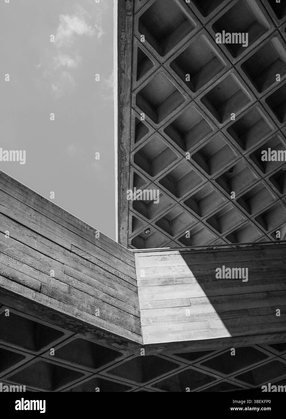 An upward view of a Brutalist architectural structure reveals its raw ...