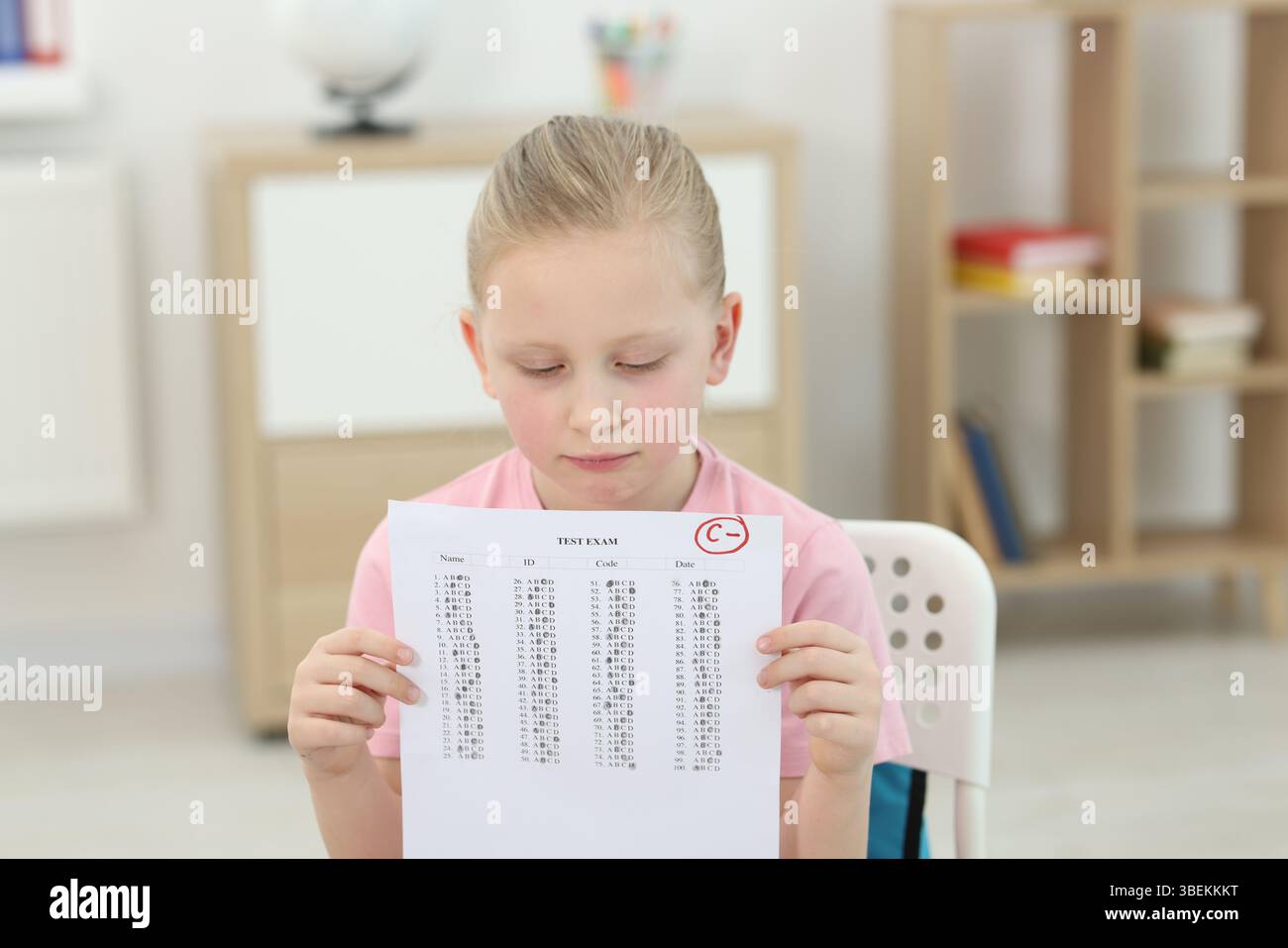 School grade. Sad girl holding answer sheet with letter C and minus ...