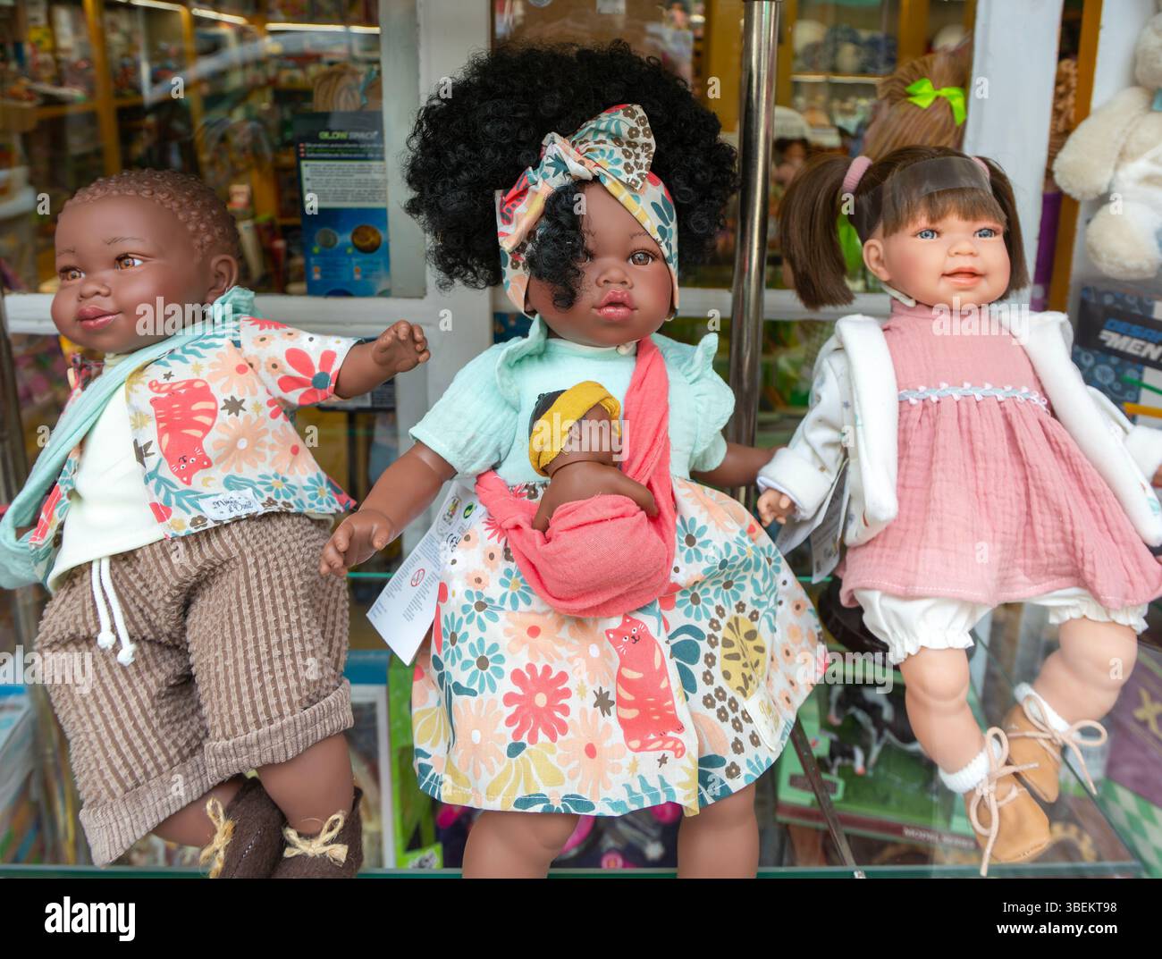 Caucasian and black skinned dolls on display in toy shop window, city ...