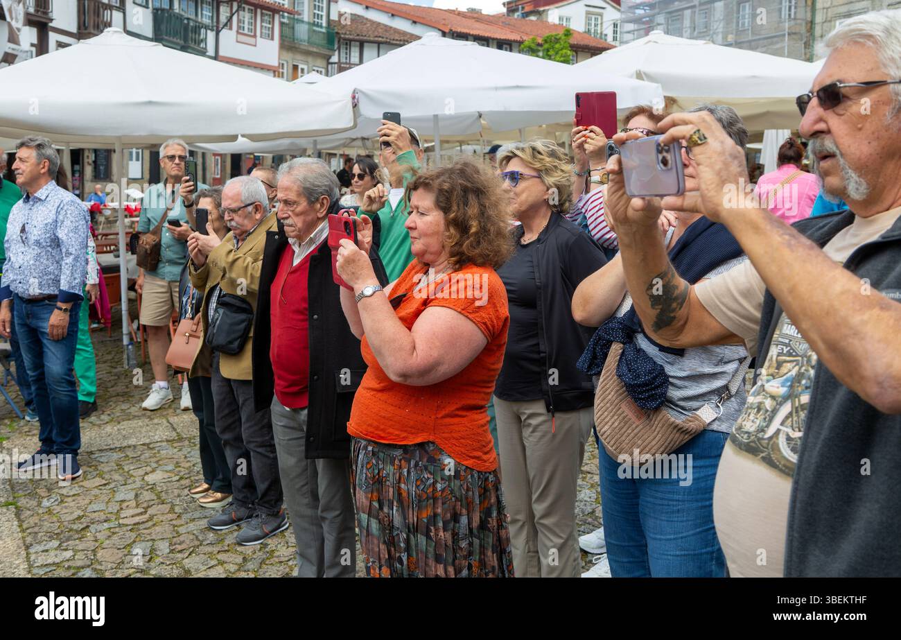 People taking photos with their phones, Praça de São Tiago, city of ...