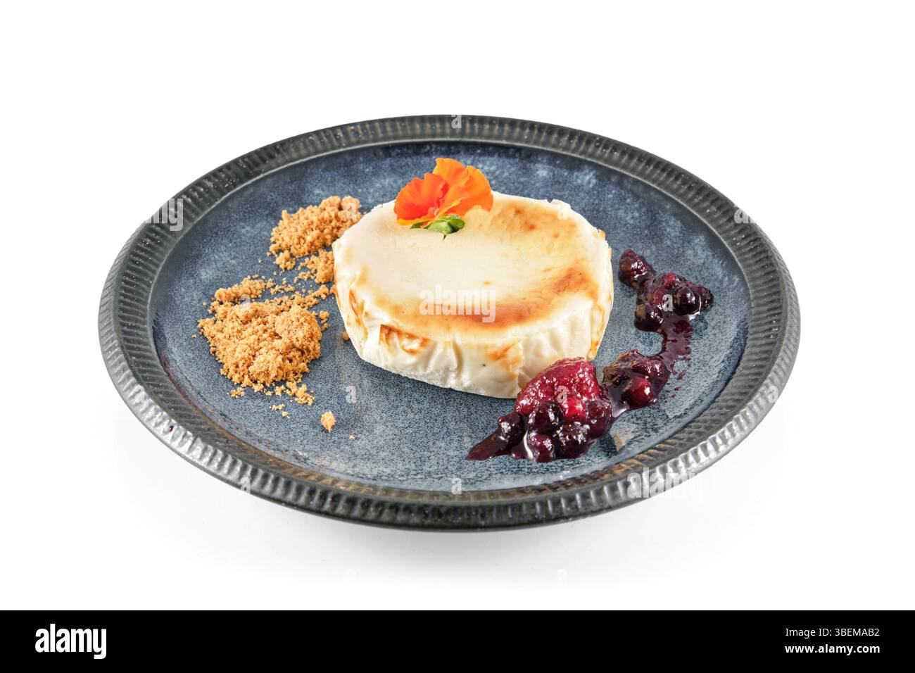 Creamy san sebastian cheesecake served with biscuit crumbs and berry ...