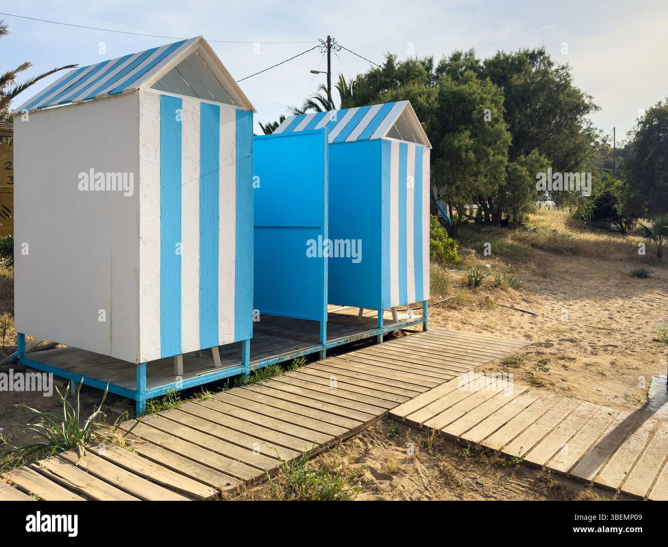 Beach cabins on sand. Small huts with blue stripes, sandy beach in ...