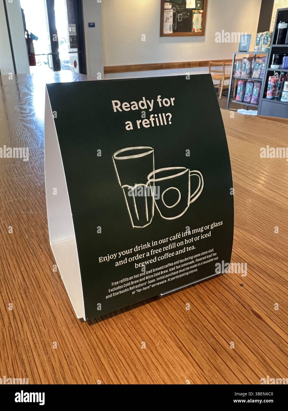 Tabletop sign advertising free coffee and tea refills inside a ...