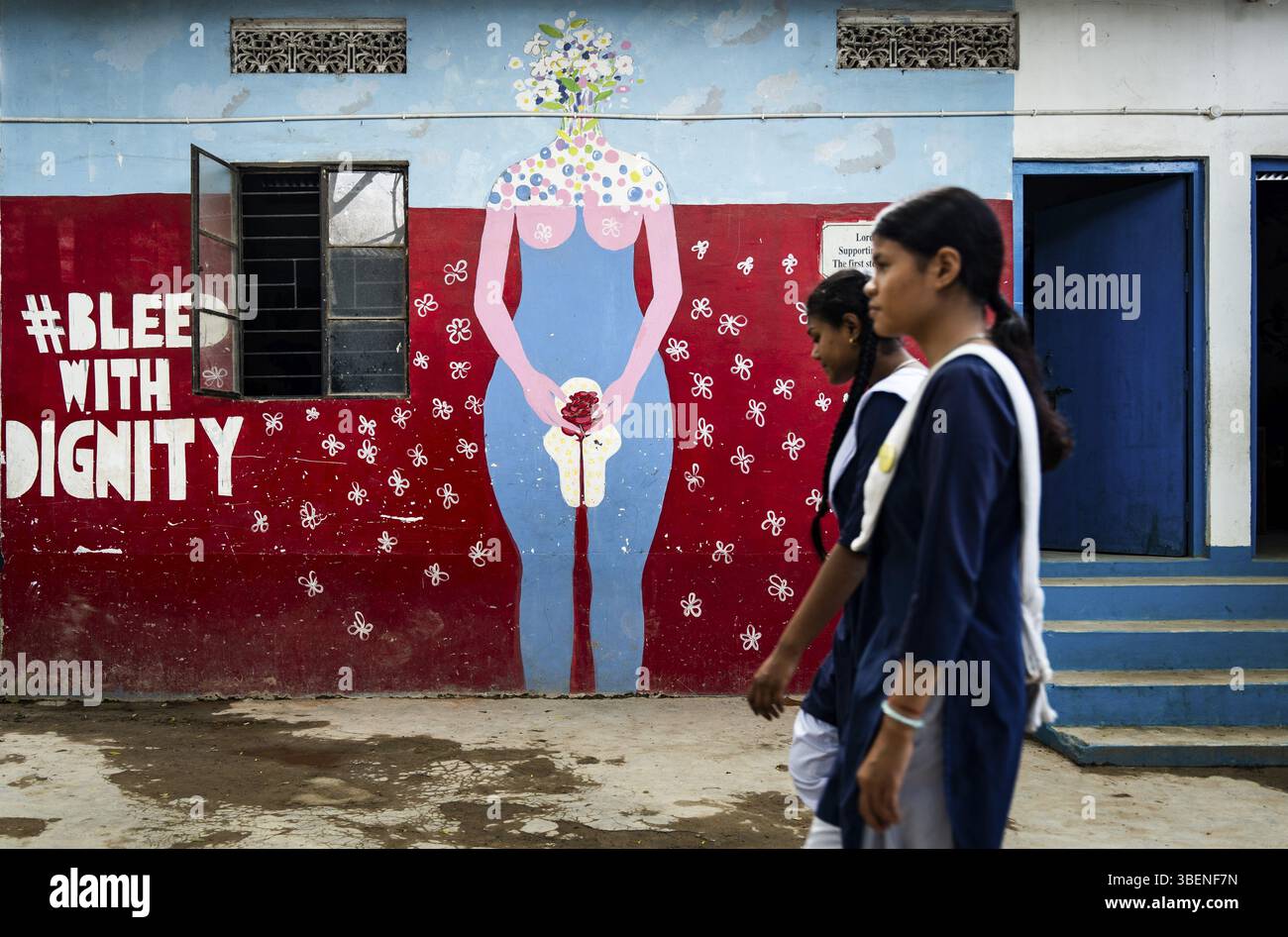 Students walk past a mural about female menstruation at Parijat Academy ...