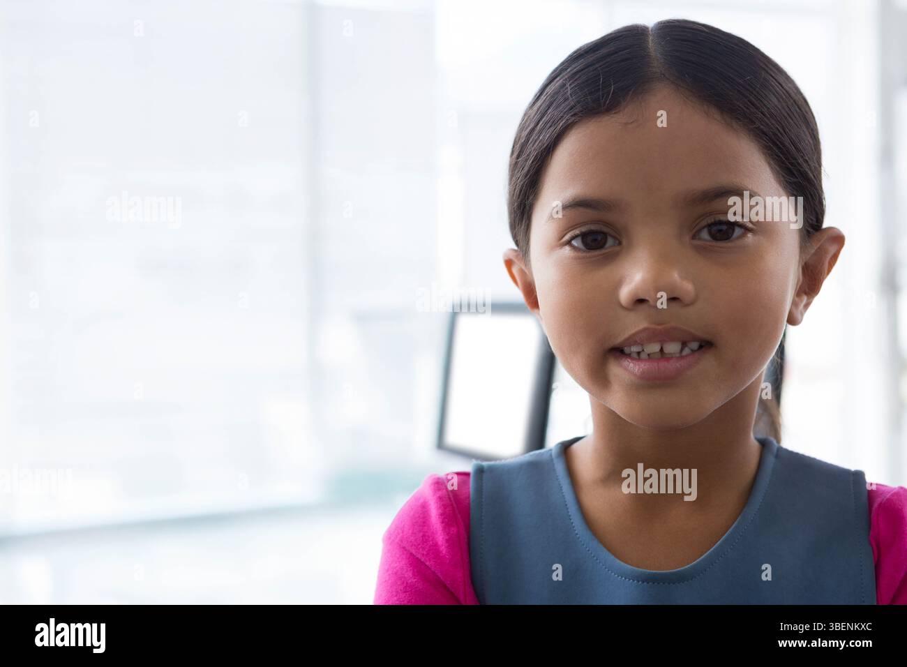 African American female child standing near desk with computer monitor ...