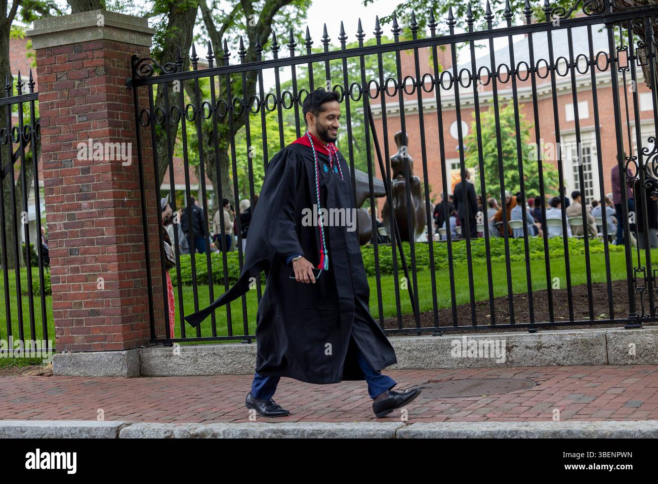 A recent graduates walks past campus during Harvard University’s 374th ...
