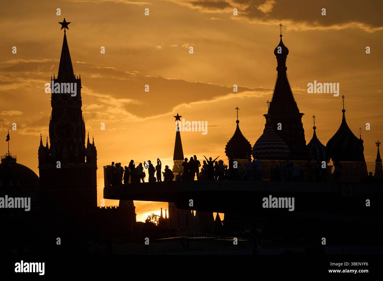 People watch and photograph sunset behind the Kremlin standing on the ...