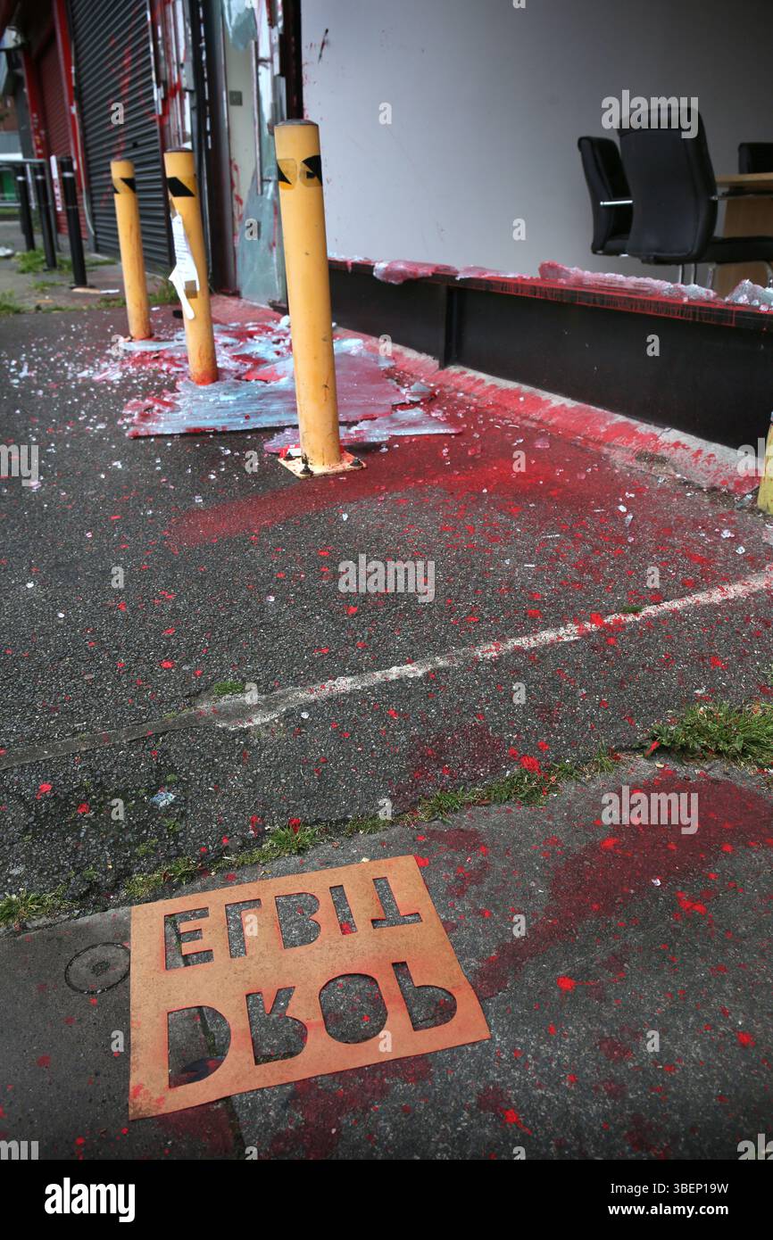 Red paint is splashed on the outside of their office building, windows ...