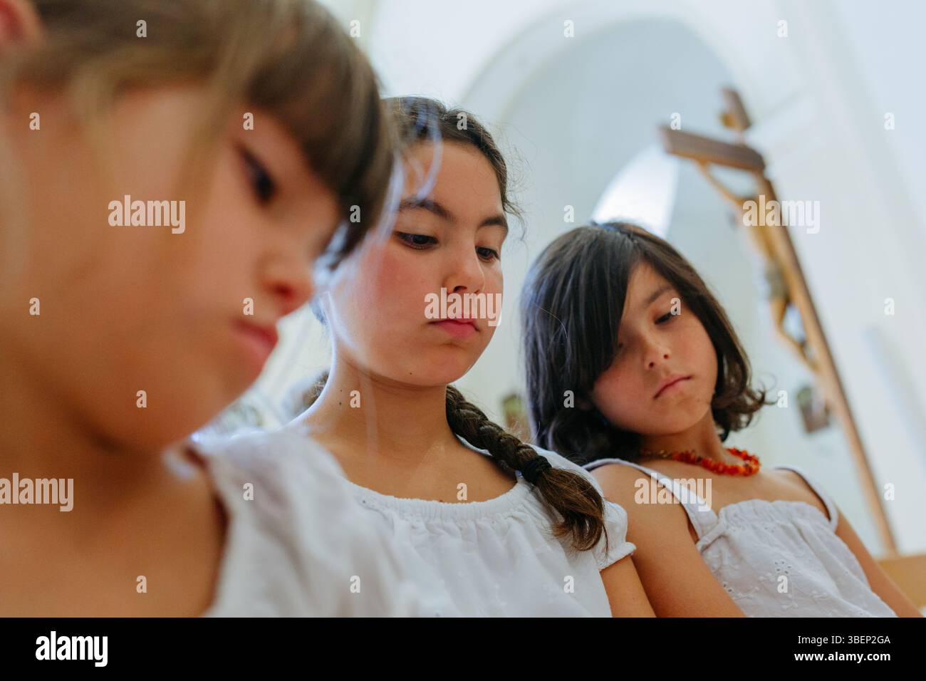 low angle view of three small girls wearing white clothes in the church ...