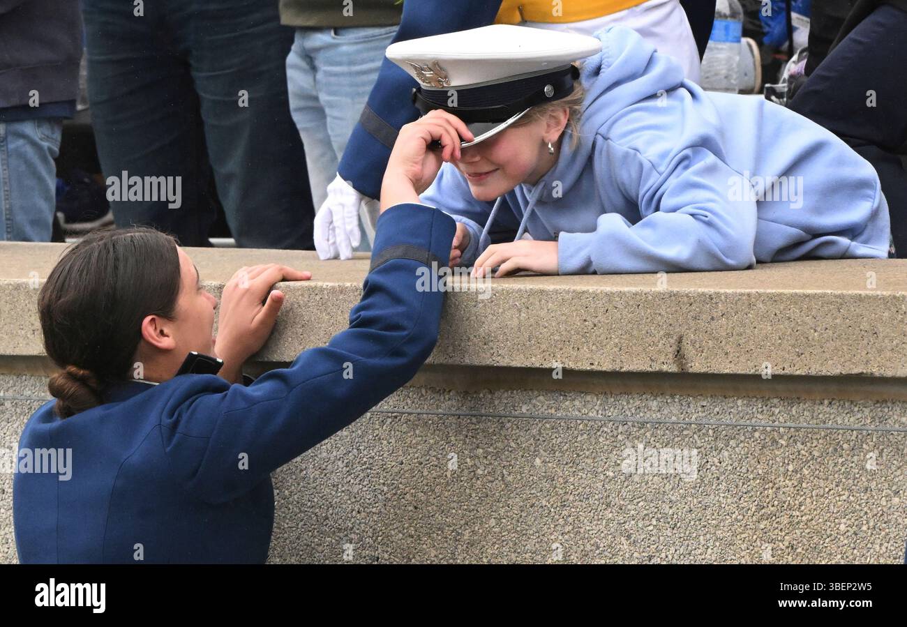 Graduating cadet Alaynee Hawley places her hat on her little sister ...