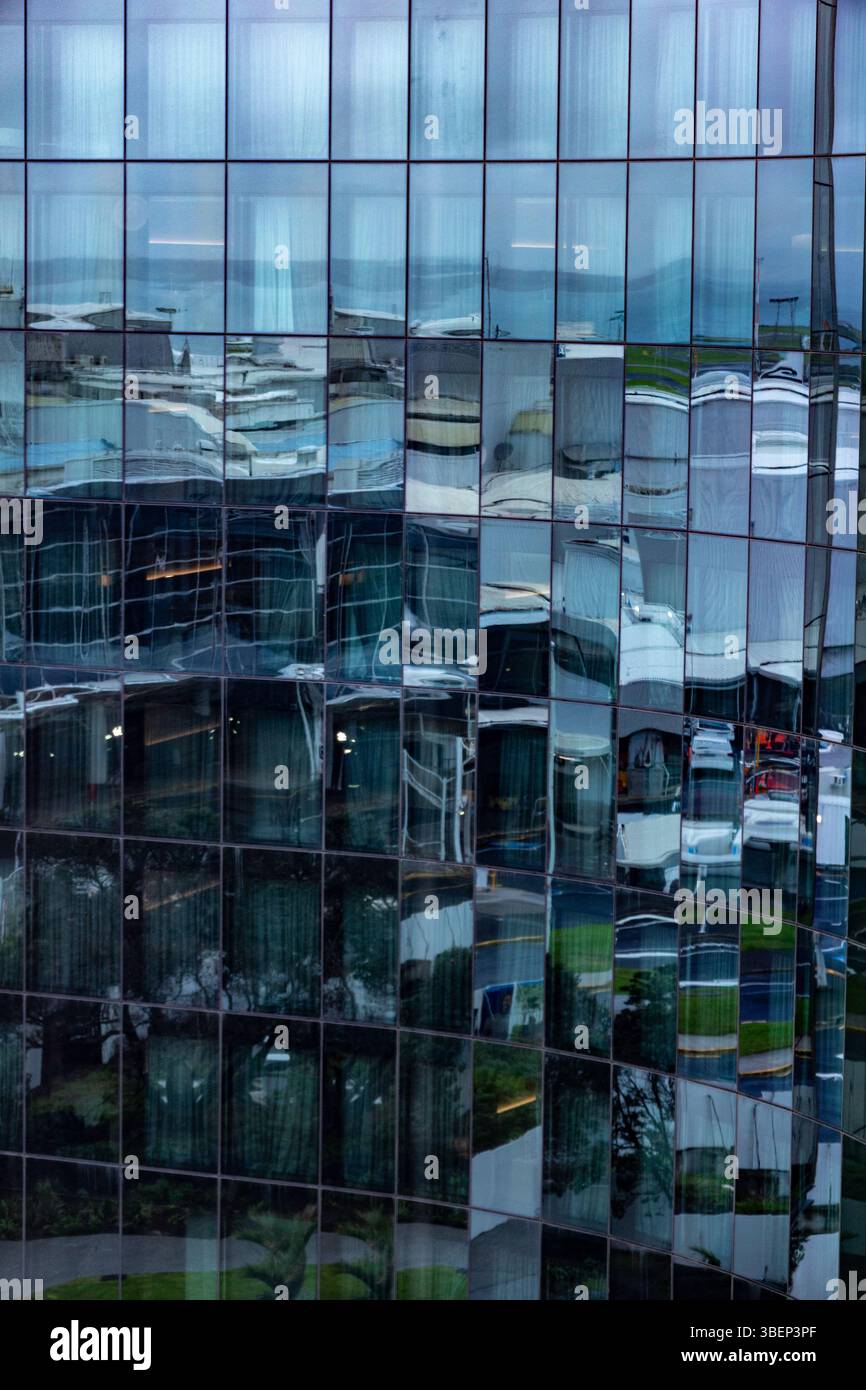 Windows reflections in grid pattern on side of commercial building ...