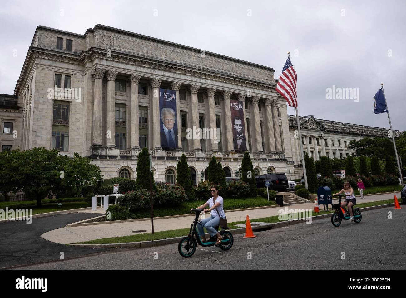 A banner with an image of President Donald Trump hangs outside ...