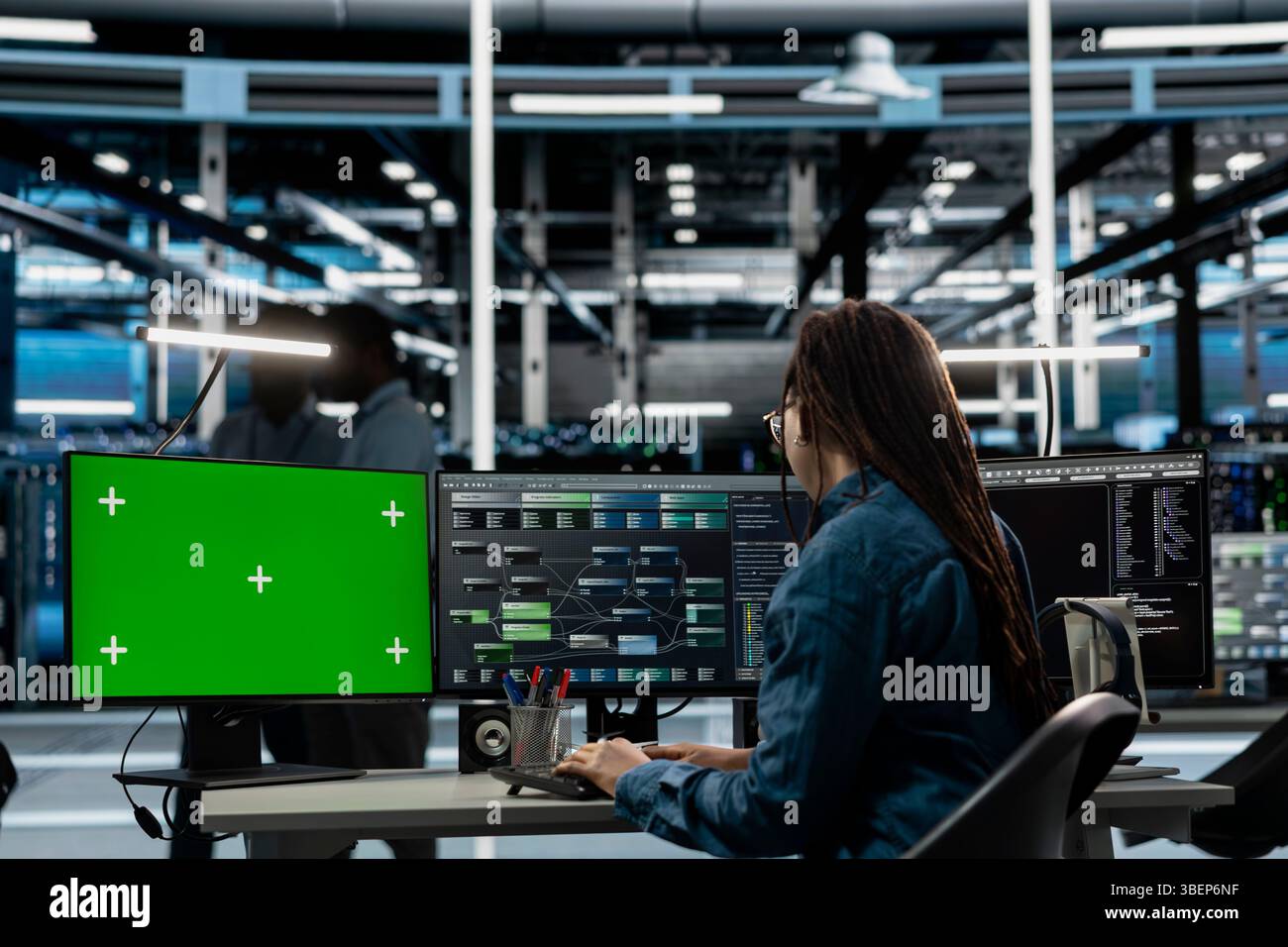 Engineer using machine l;earning tech on green screen PC in data center ...