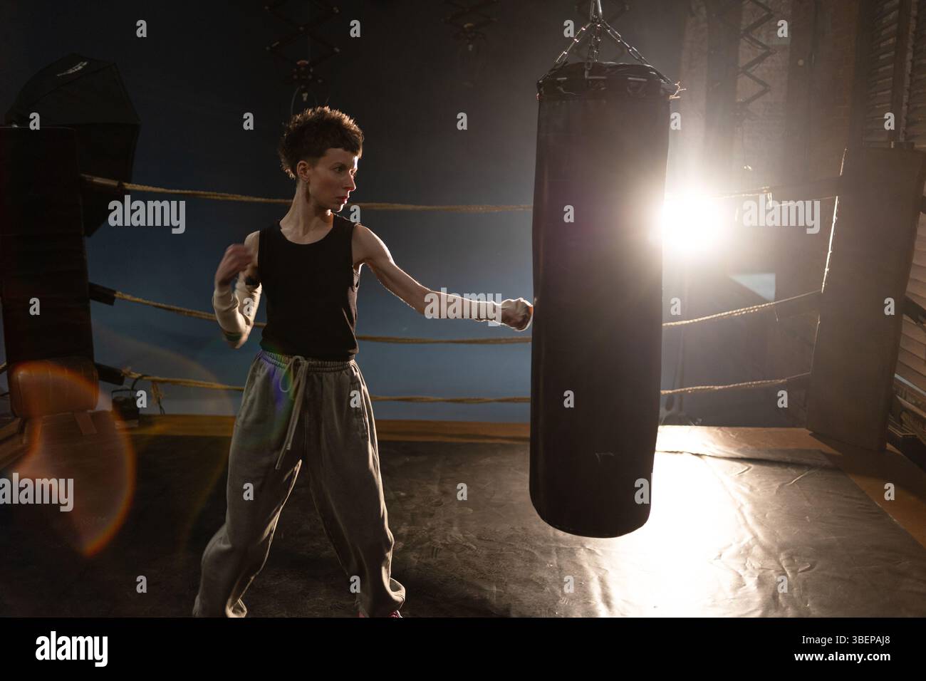 Female athlete boxing in dim gym lights, cinematic punch moment with ...