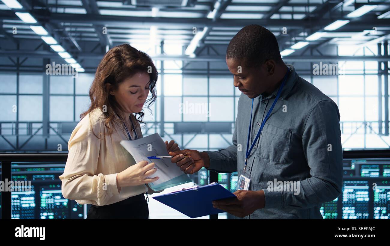 Team of data center supervisors reading paperwork files, reviewing ...