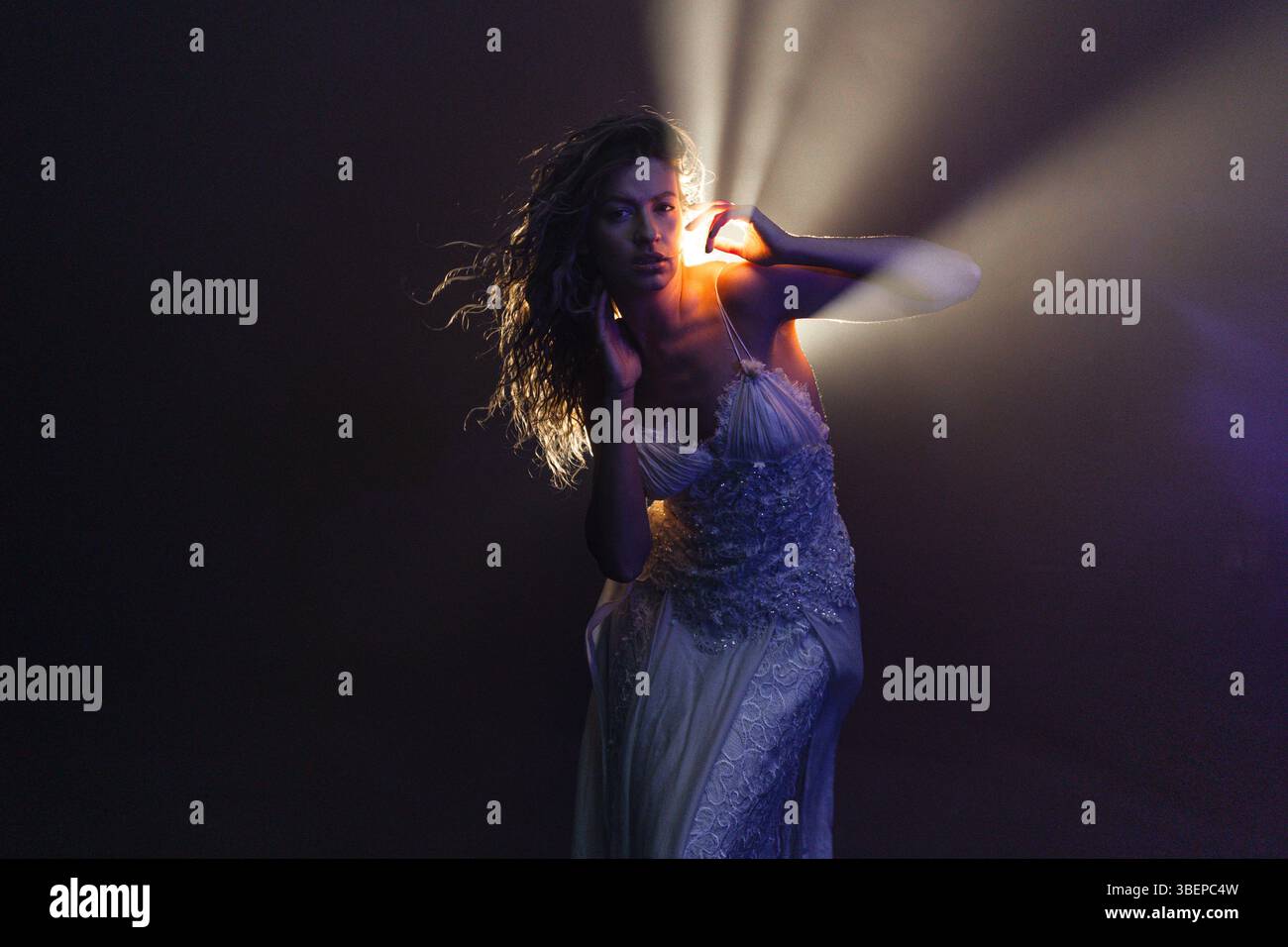 Dreamlike moment as woman in white dress twirls, backlit by mysterious ...