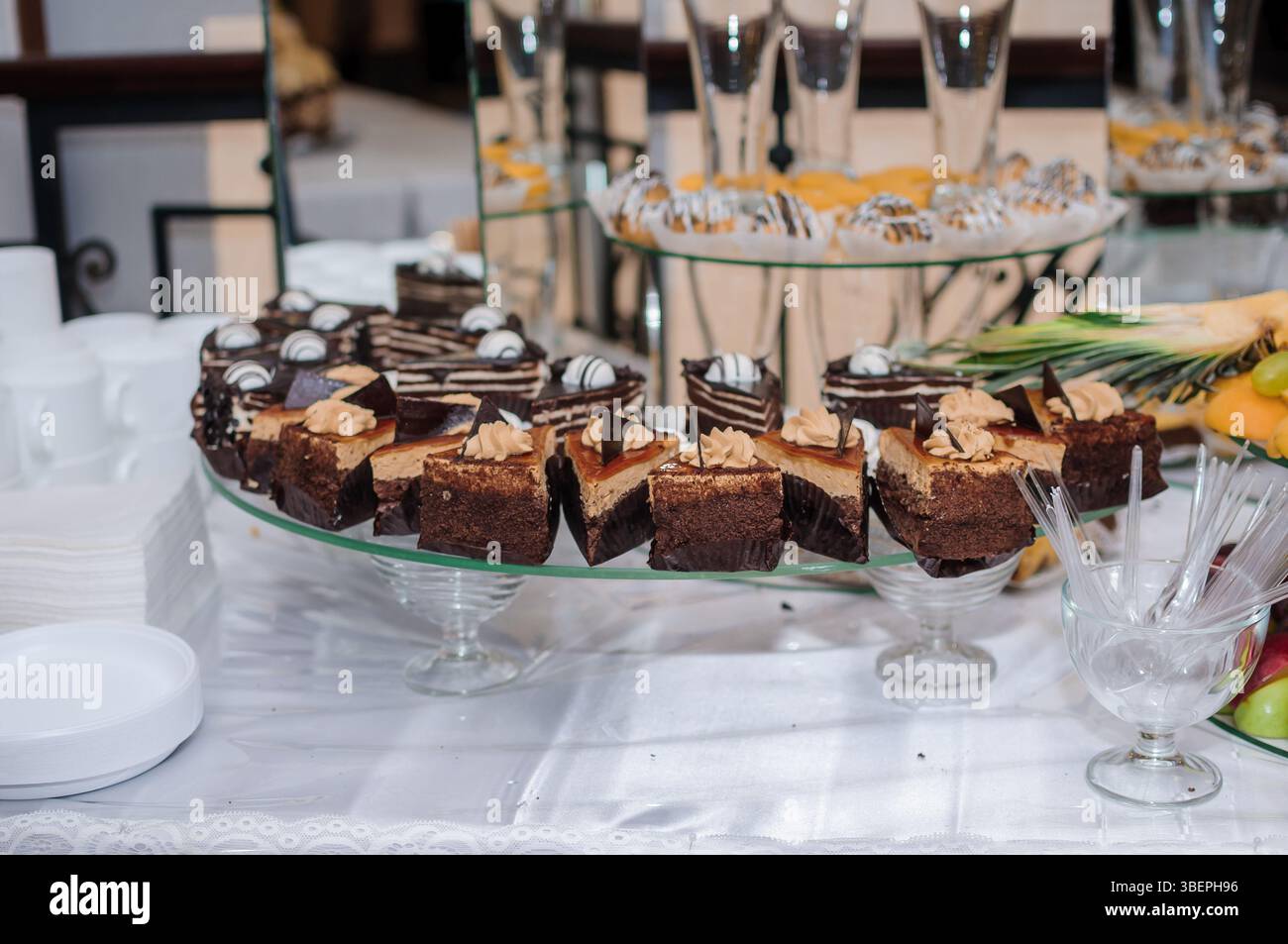 A lavish dessert spread at a wedding reception showcases tiered displays of assorted chocolate ...