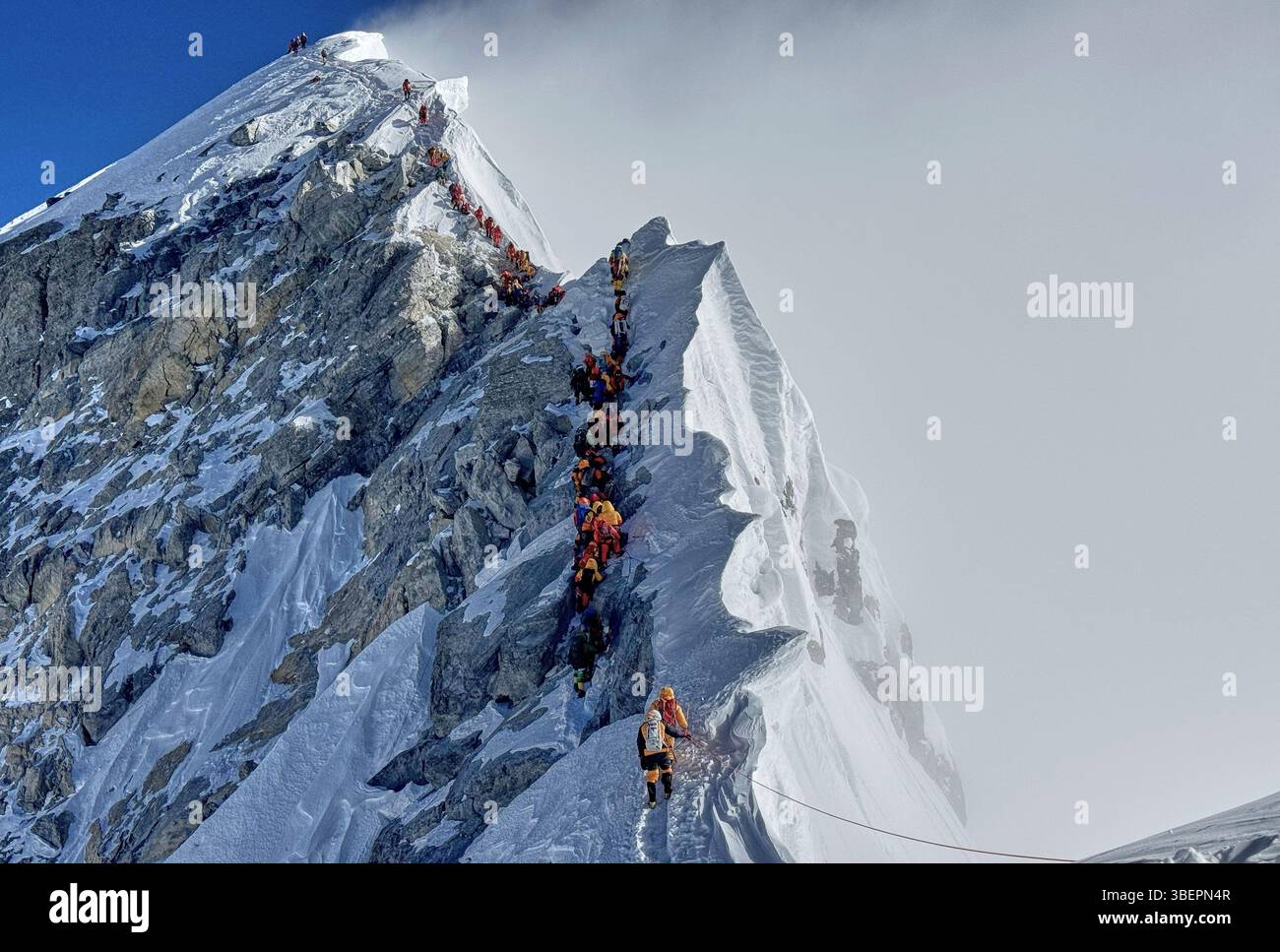 Mountaineers form a queue as they approach the summit of Mount Everest ...