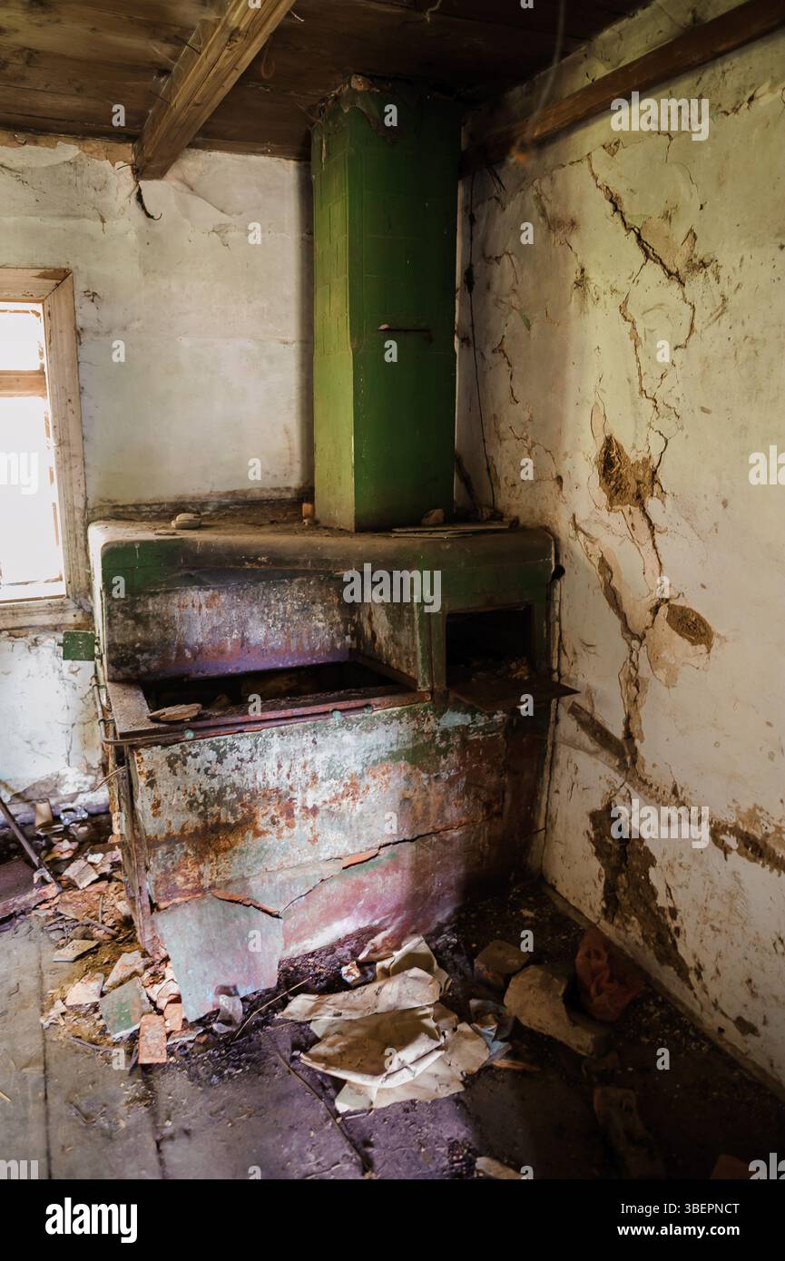 Dilapidated interior of abandoned house featuring a vintage green stove ...